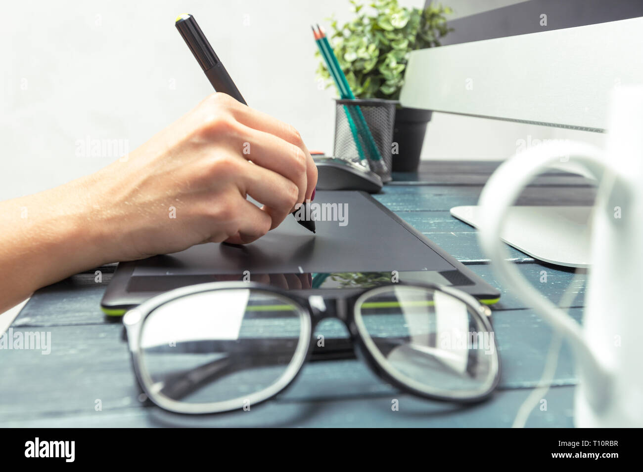 Hand of graphic designer working with stilus and tablet Stock Photo - Alamy