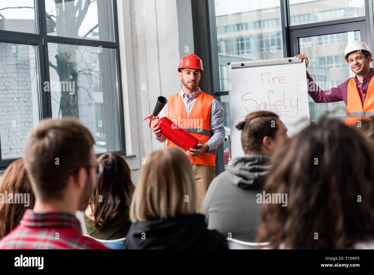selective focus of handsome fireman in helmet holding extinguisher ...