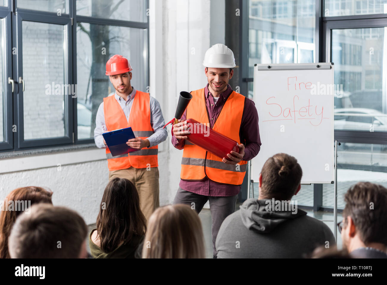 selective focus of handsome firemen in helmets standing near white ...