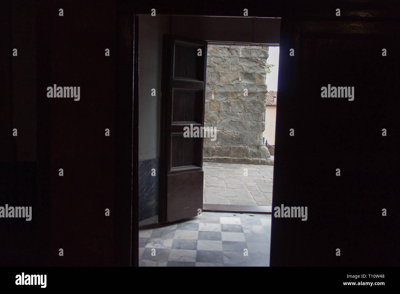 The view of exit door at the end of a dark ancient room in castle or ...