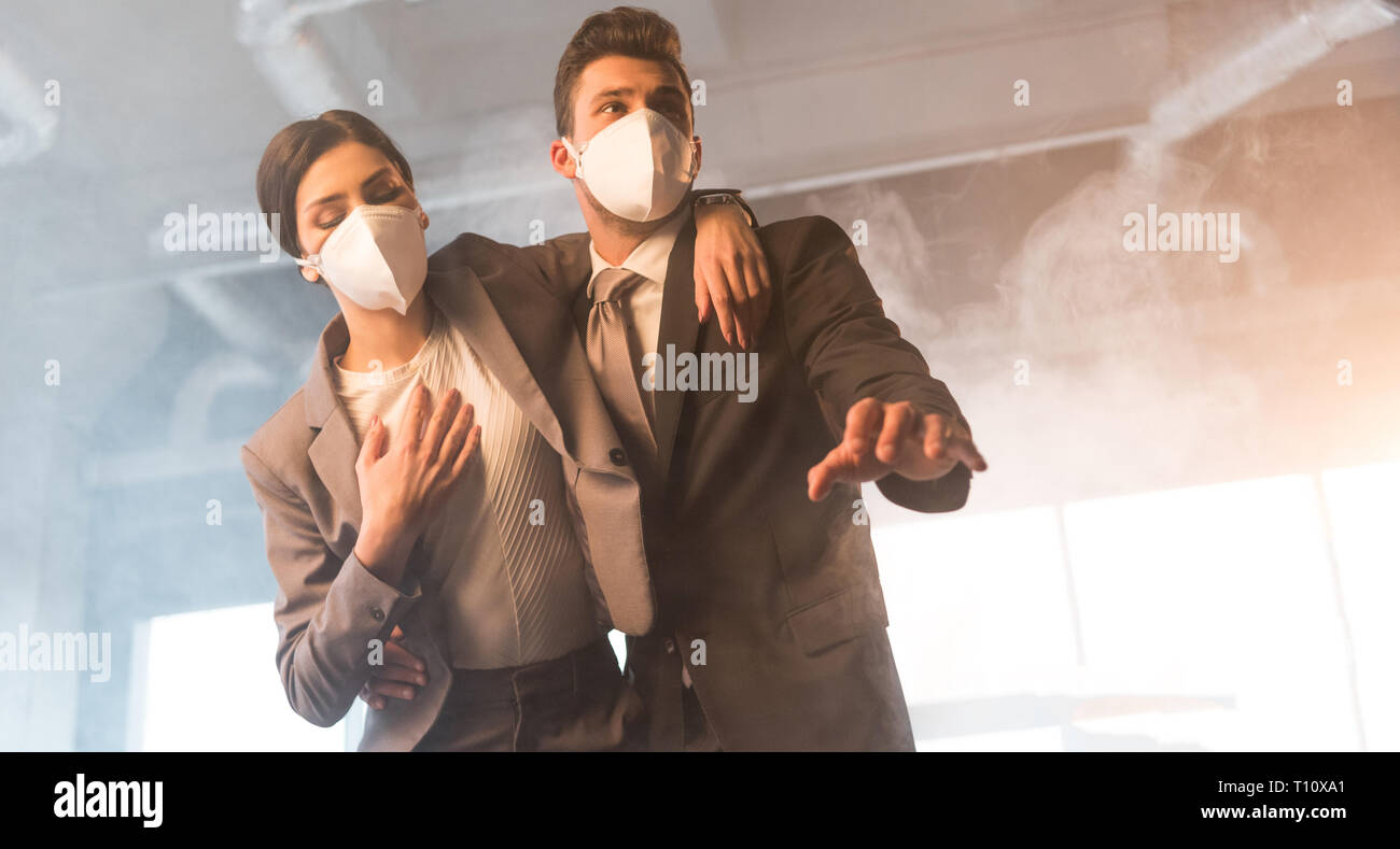 scared businessman in mask standing with female coworker in office with ...