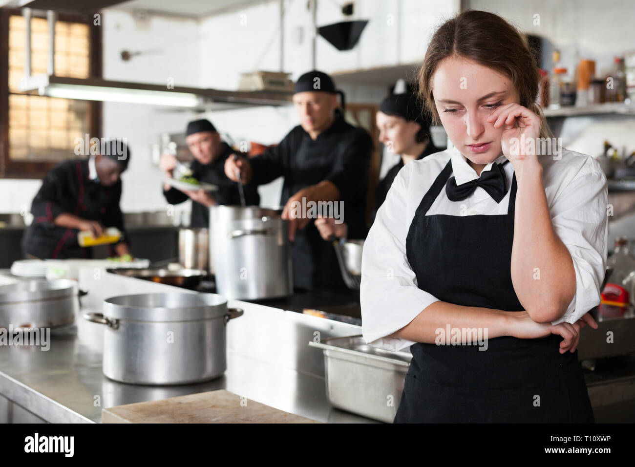 Tired and upset waitress in kitchen of restaurant Stock Photo - Alamy