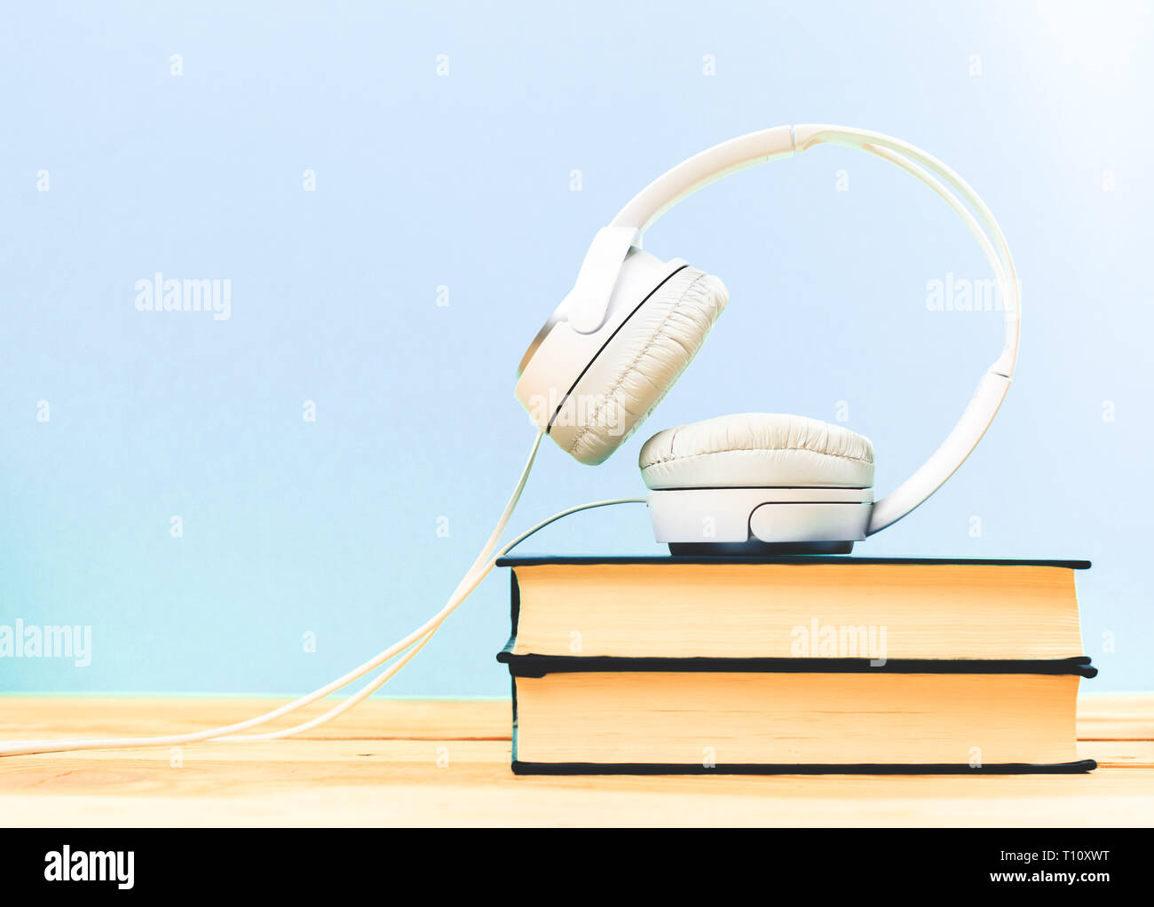 Concept of audiobook. Books on the table with headphones put on them ...