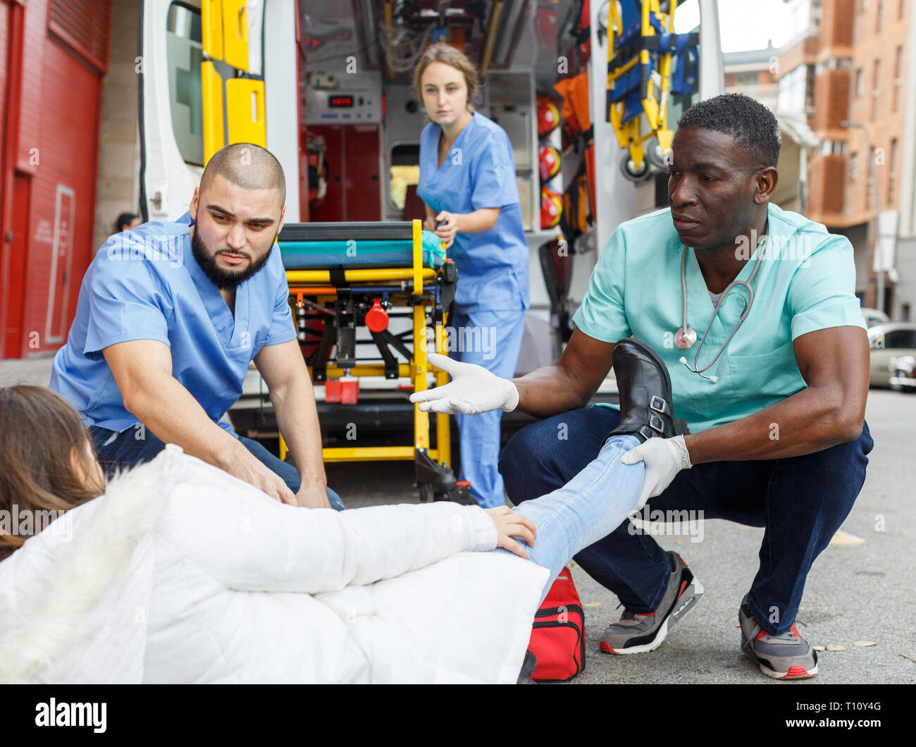 Paramedic team providing first aid to woman with injured leg Stock ...