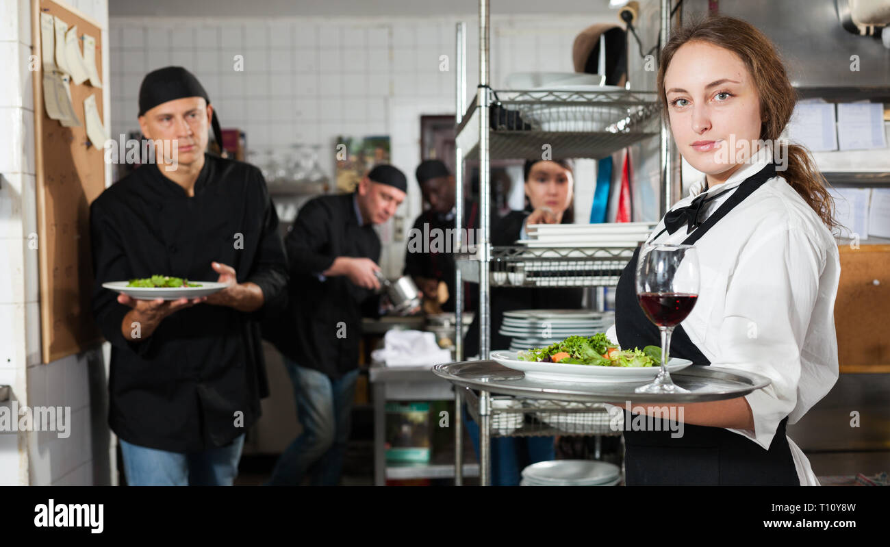Professional waitress holding serving tray at restaurant kitchen Stock ...
