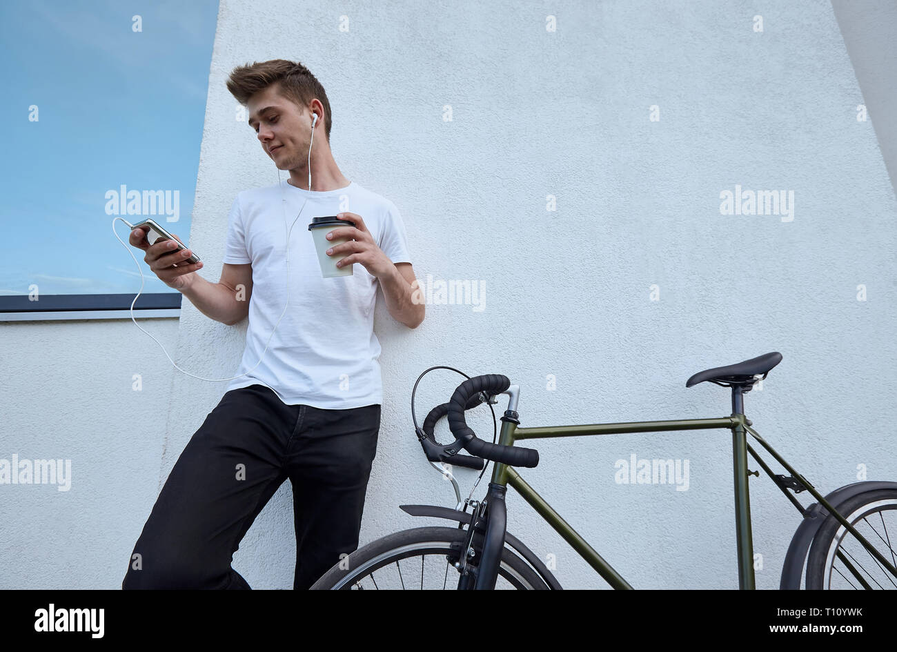 Young hipster style man posing with bicycle on the street sport style ...