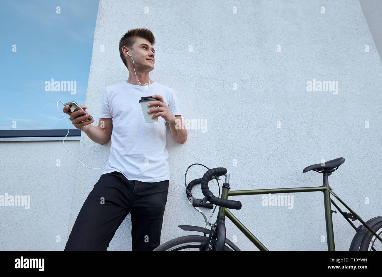Young hipster style man posing with bicycle on the street sport style ...