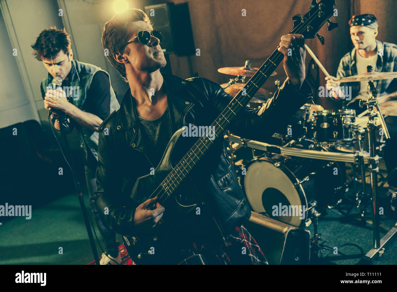 selective focus of good-looking guitarist in sunglasses playing ...