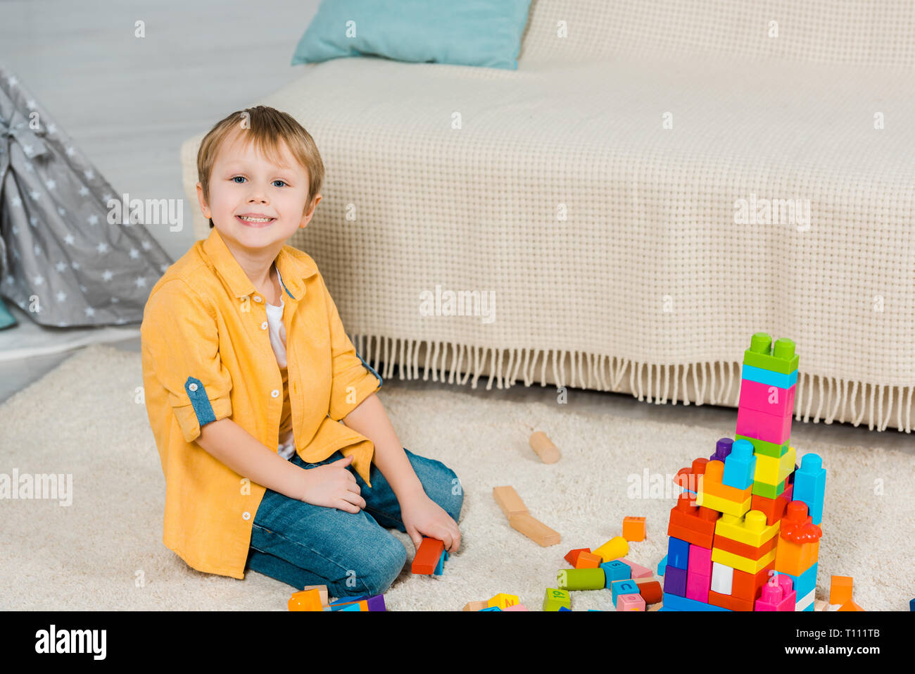 adorable preschooler boy playing with colorful building blocks at home ...