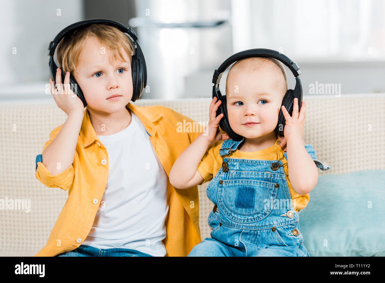 Adorable siblings listening music hi-res stock photography and images ...