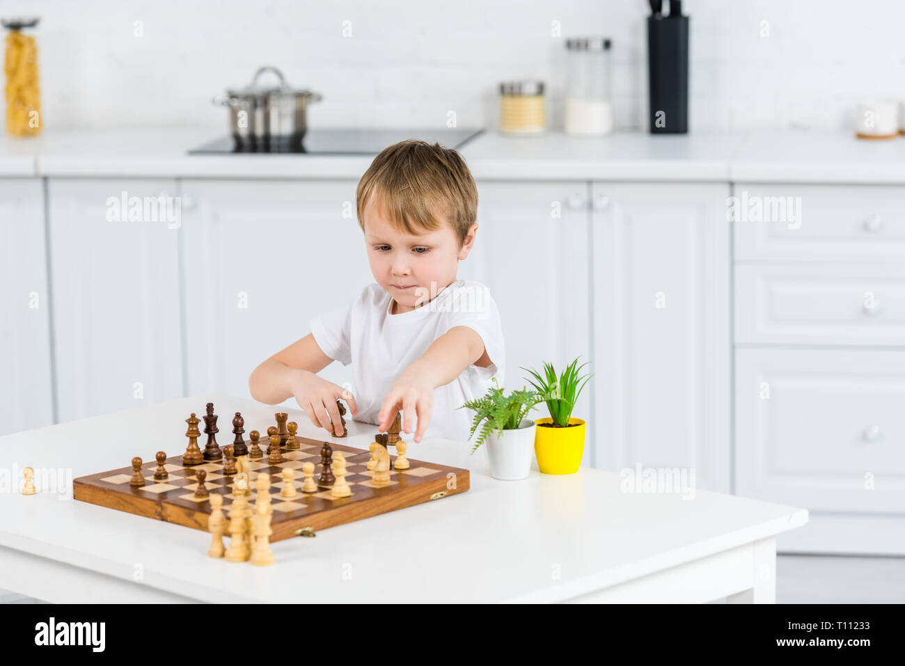 Adorable boy sitting table in hi-res stock photography and images - Alamy