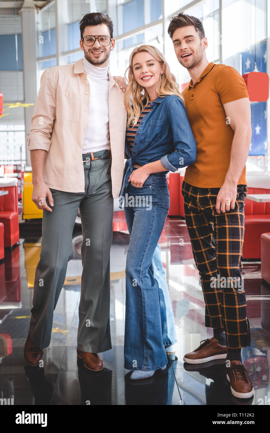 smiling and beautiful friends hugging and looking at camera Stock Photo ...