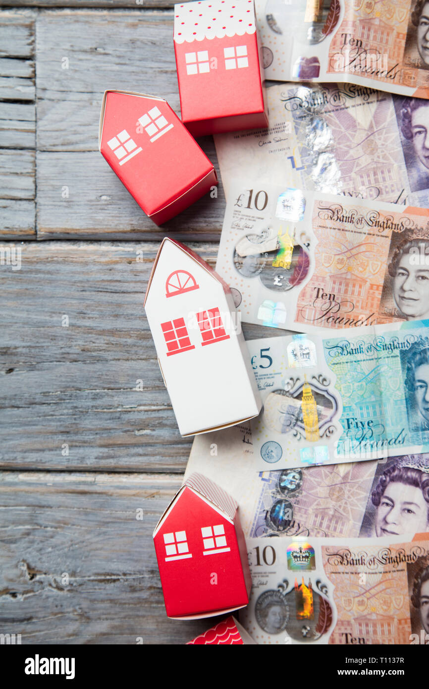 Housing cost. Paper toy house with British currency notes Stock Photo ...