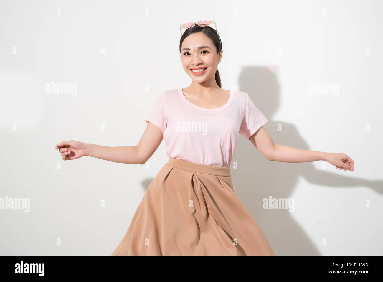 Magnificent girl dancing with smile in white studio. Indoor portrait of ...
