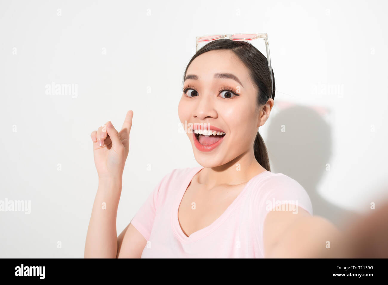 Young happy smile girl take selfie on white background Stock Photo - Alamy