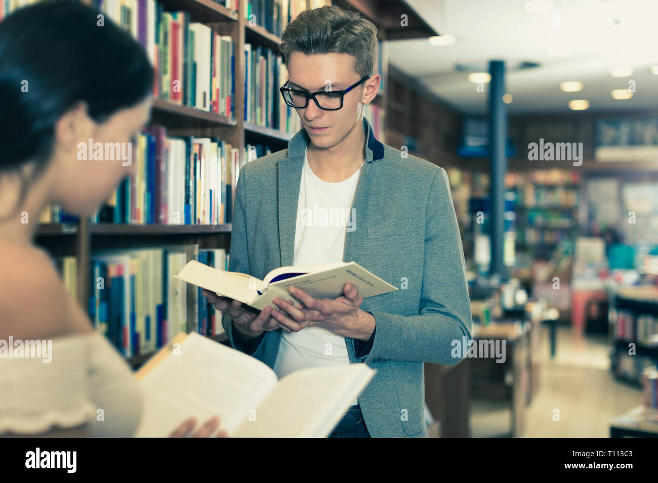 man searching for information in books in bookstore Stock Photo - Alamy