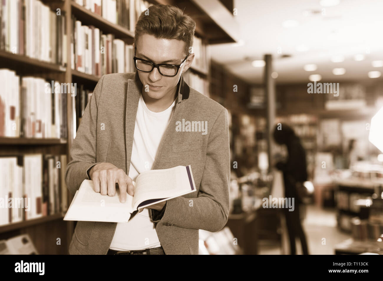 Serious positive man pointing at something in open book at bookstore ...