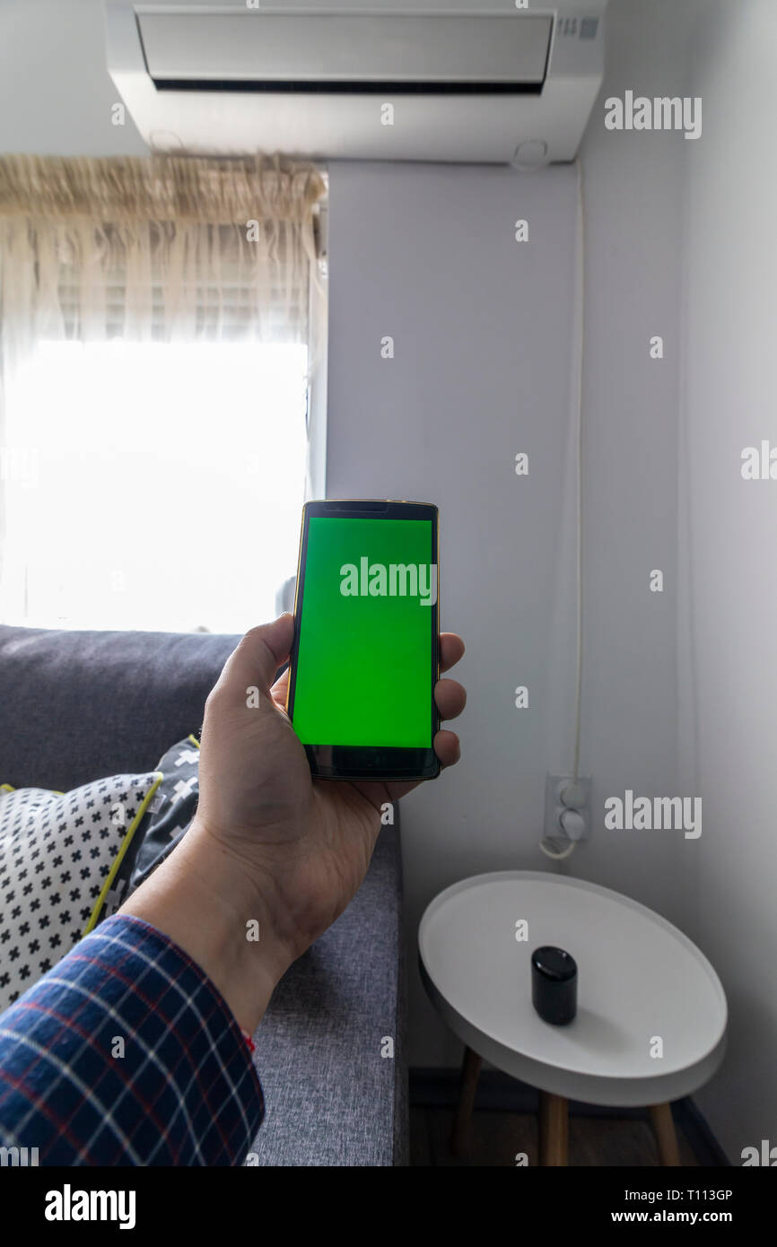 Air conditioner smartphone remote control concept. Hand holding a phone ...