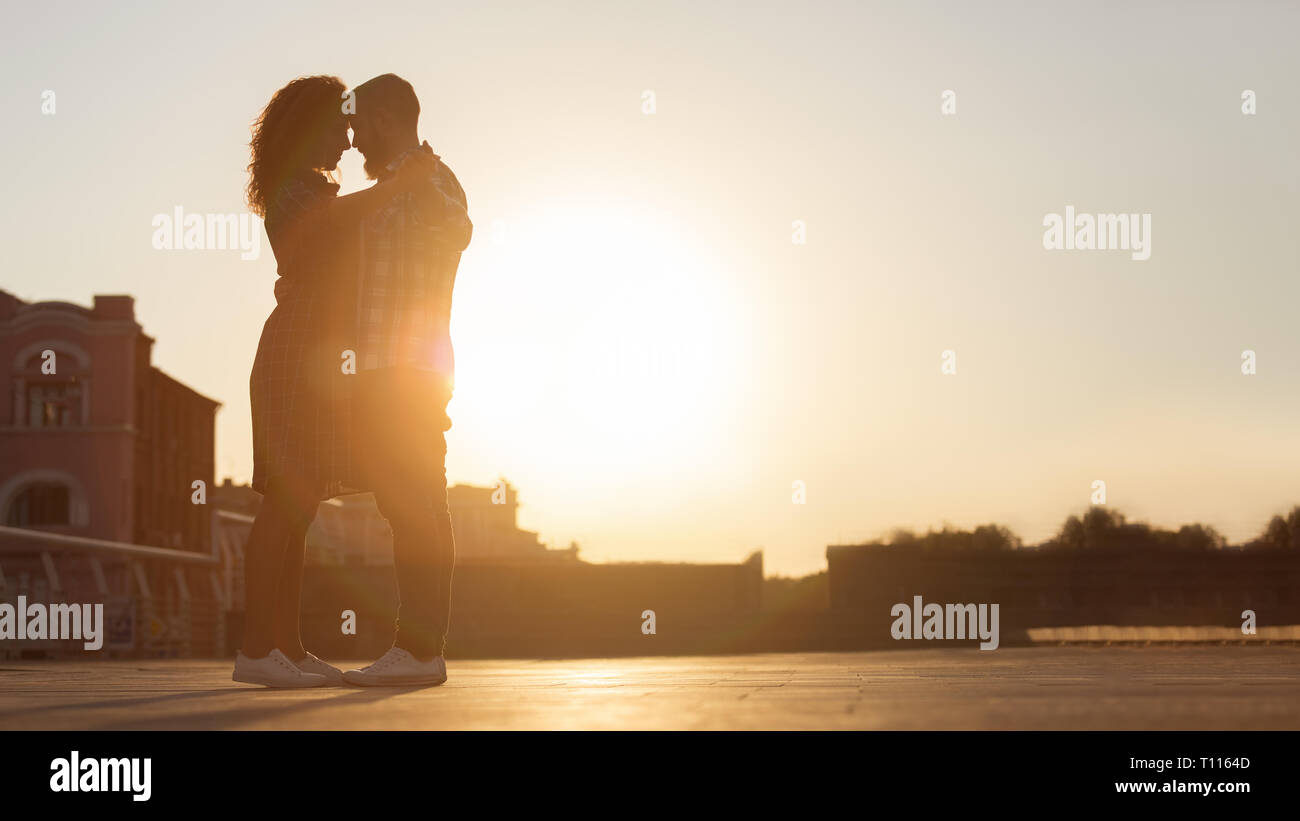Young couple hugging and kissing outdoors at sunset background Stock ...