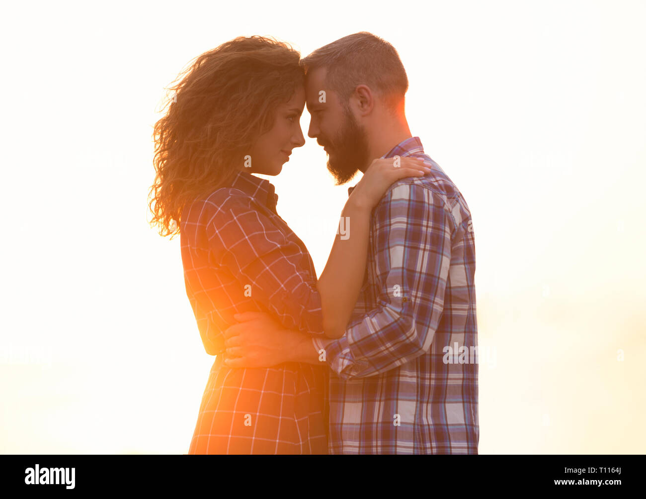 Profile of serene couple bonding to each other against sunset Stock ...