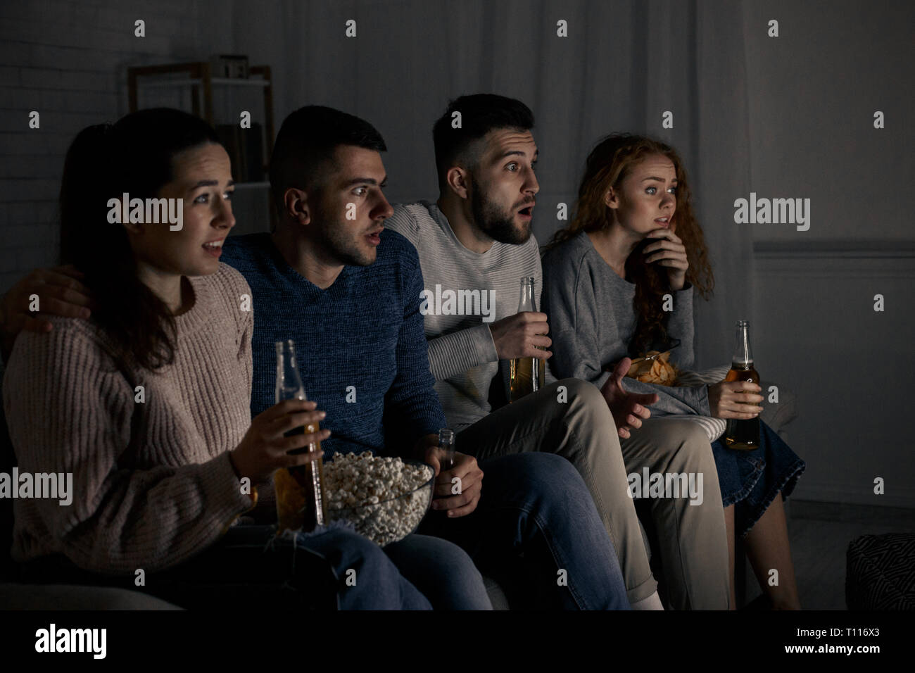 Shocked friends watching horror movie with popcorn Stock Photo - Alamy
