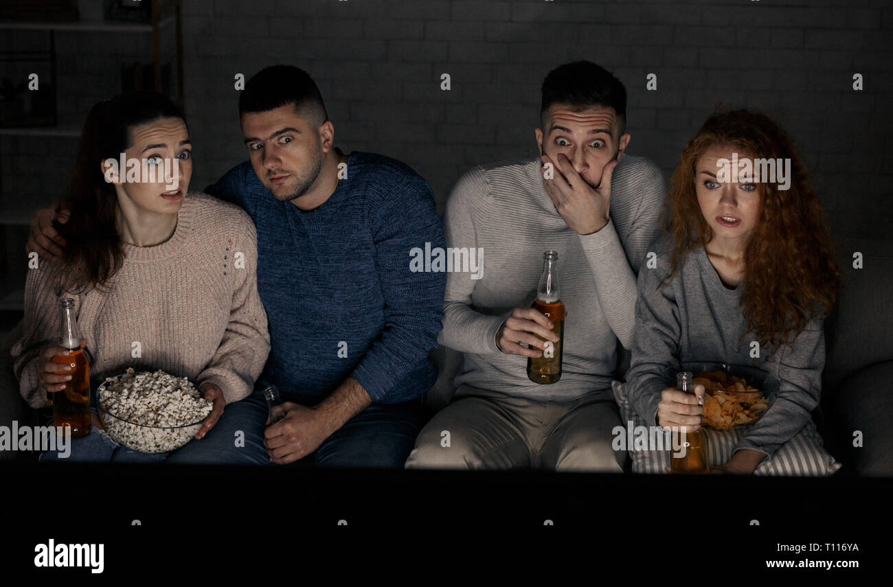 Scared friends watching horror film and drinking beers Stock Photo - Alamy