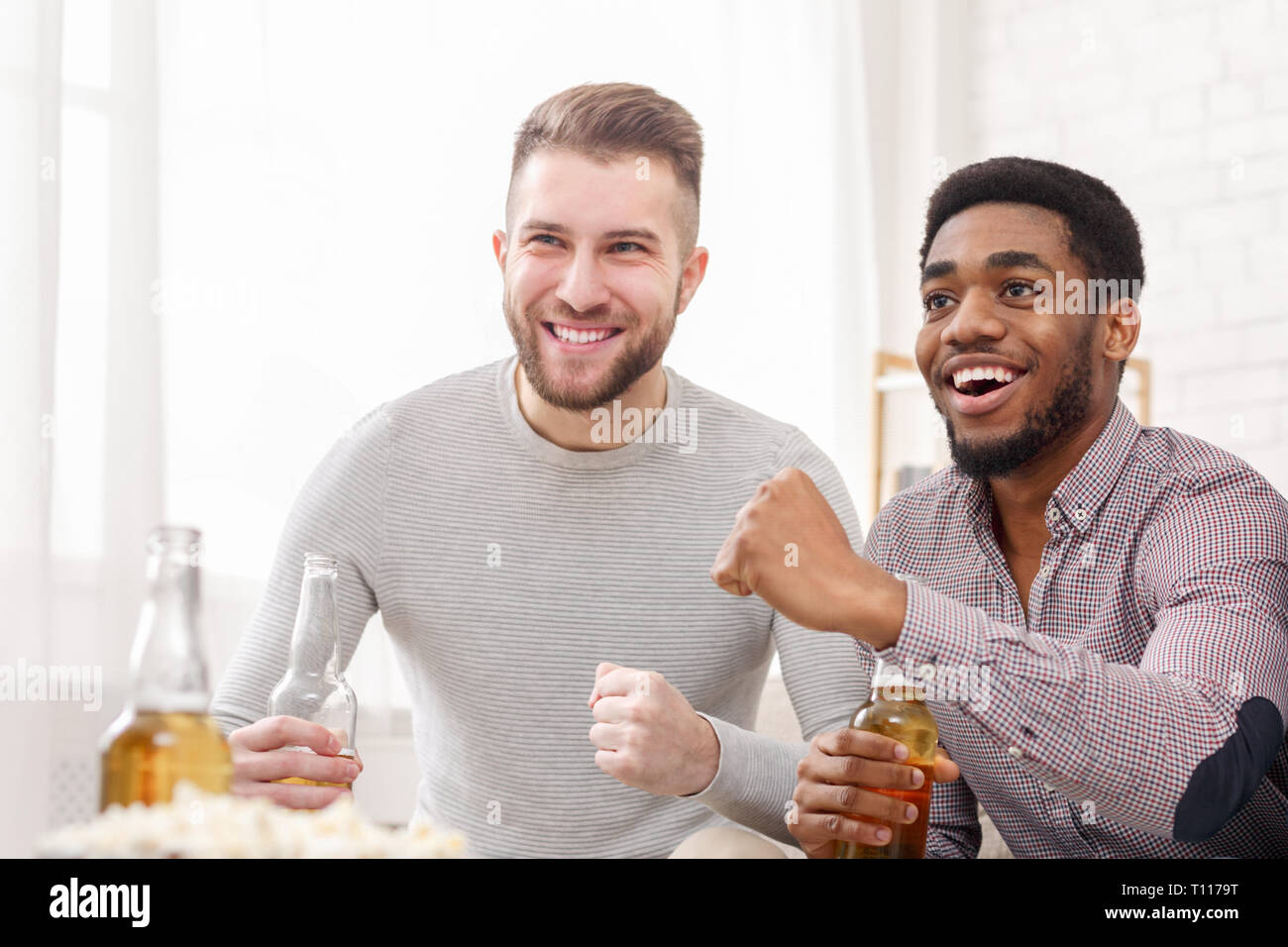 Guys drinking beer and cheering for football Stock Photo - Alamy