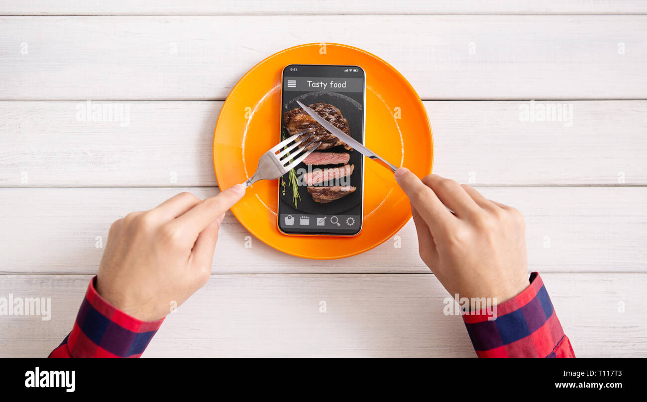 Man eating steak image on cellphone screen Stock Photo - Alamy