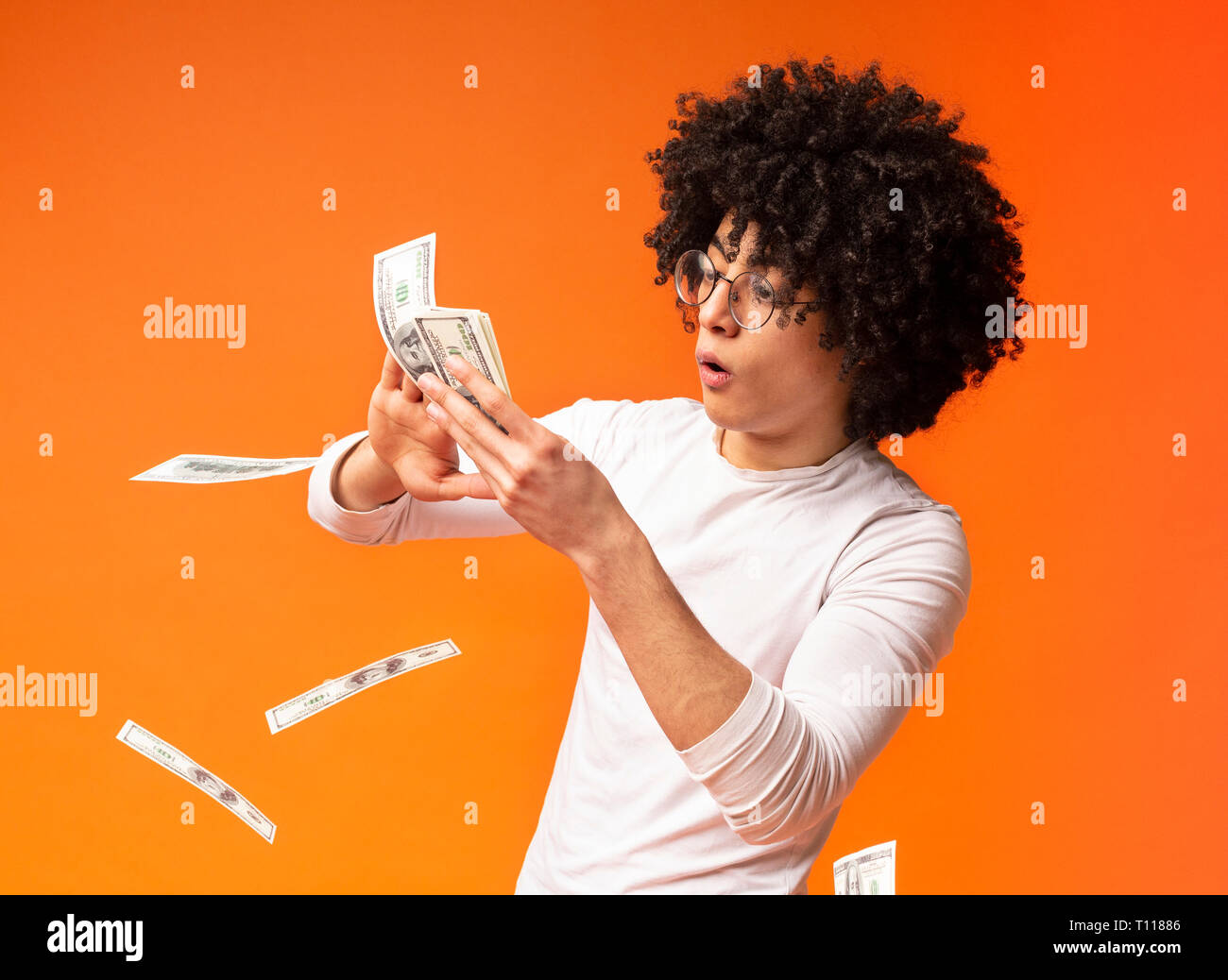 Happy young man throwing out money banknotes Stock Photo - Alamy