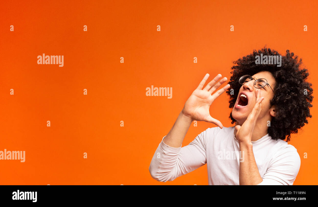 Emotional black guy screaming on orange panorama background Stock Photo ...