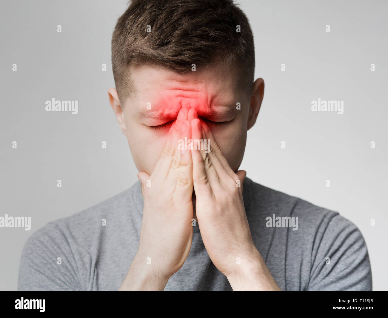 Sad man holding his nose because sinus pain Stock Photo - Alamy