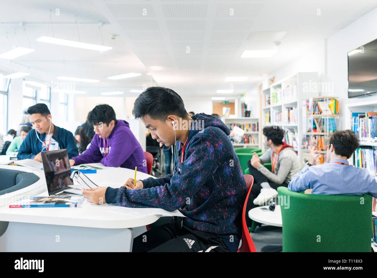 students sit and work to revise in the school / college library Stock ...