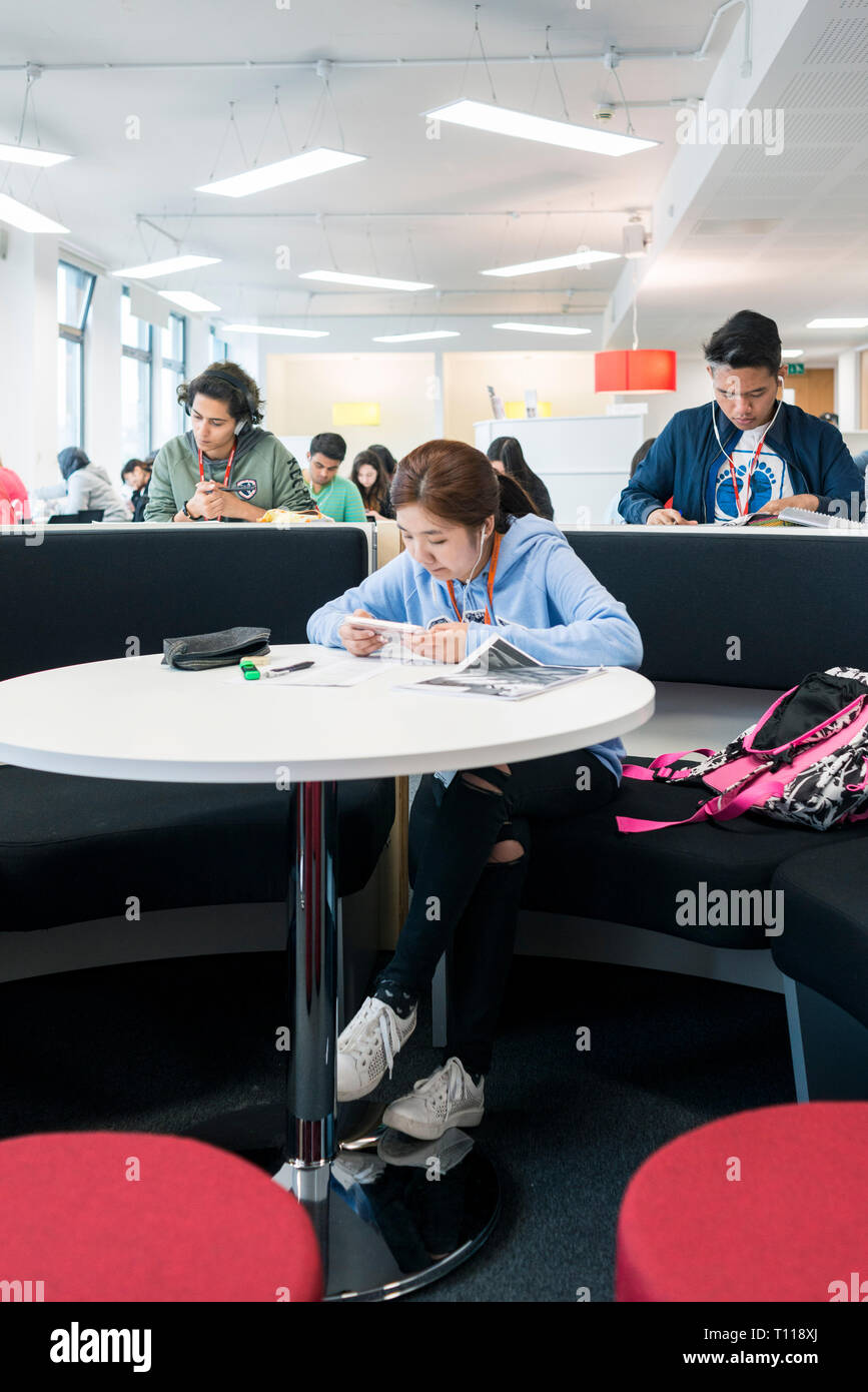 students sit and work to revise in the school / college library Stock ...