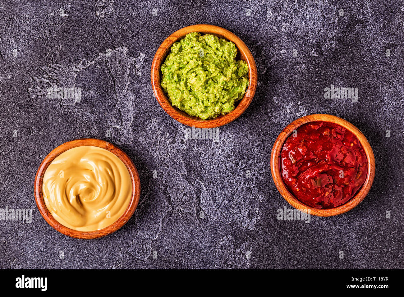 Mexican food background: guacamole, salsa, cheesy sauces with ...