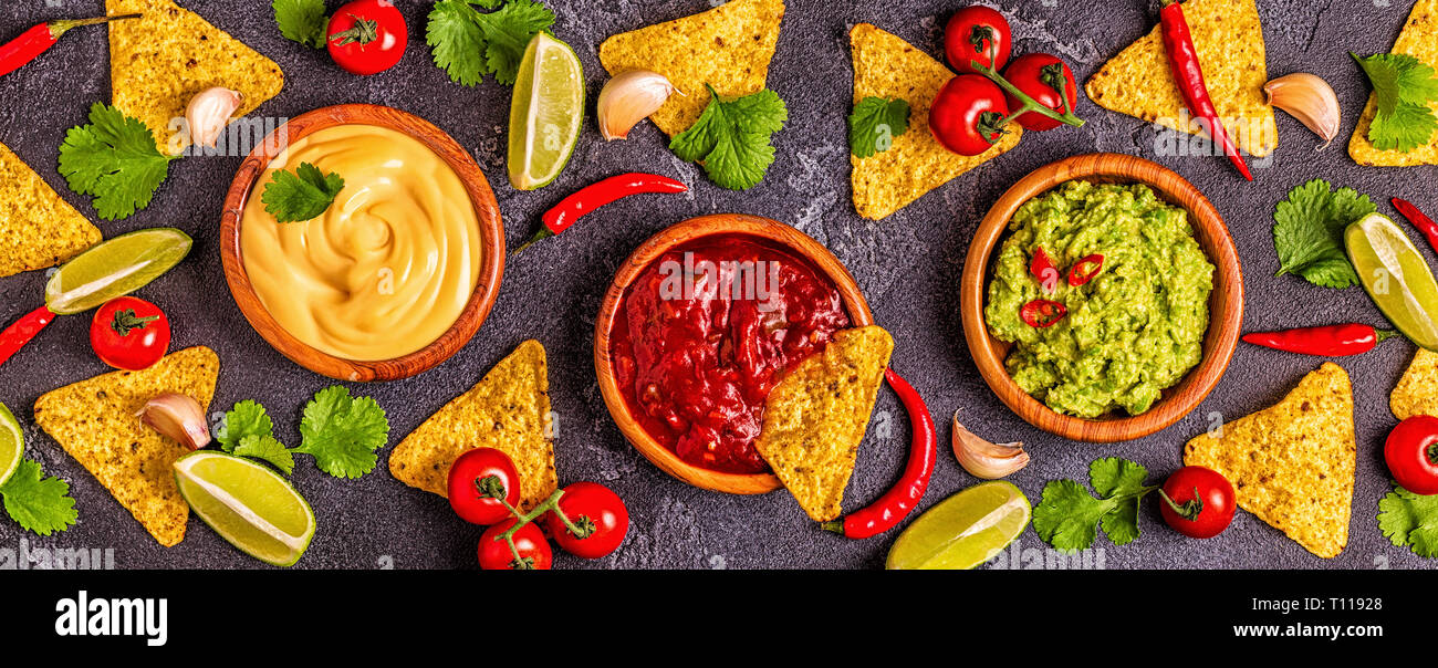 Mexican food background: guacamole, salsa, cheesy sauces with ...