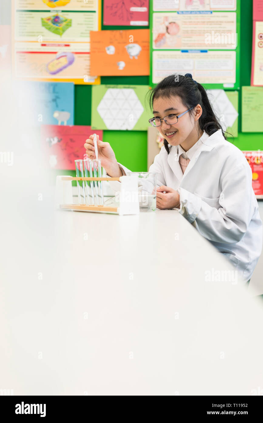 a female international asian student in the science lab of her college ...