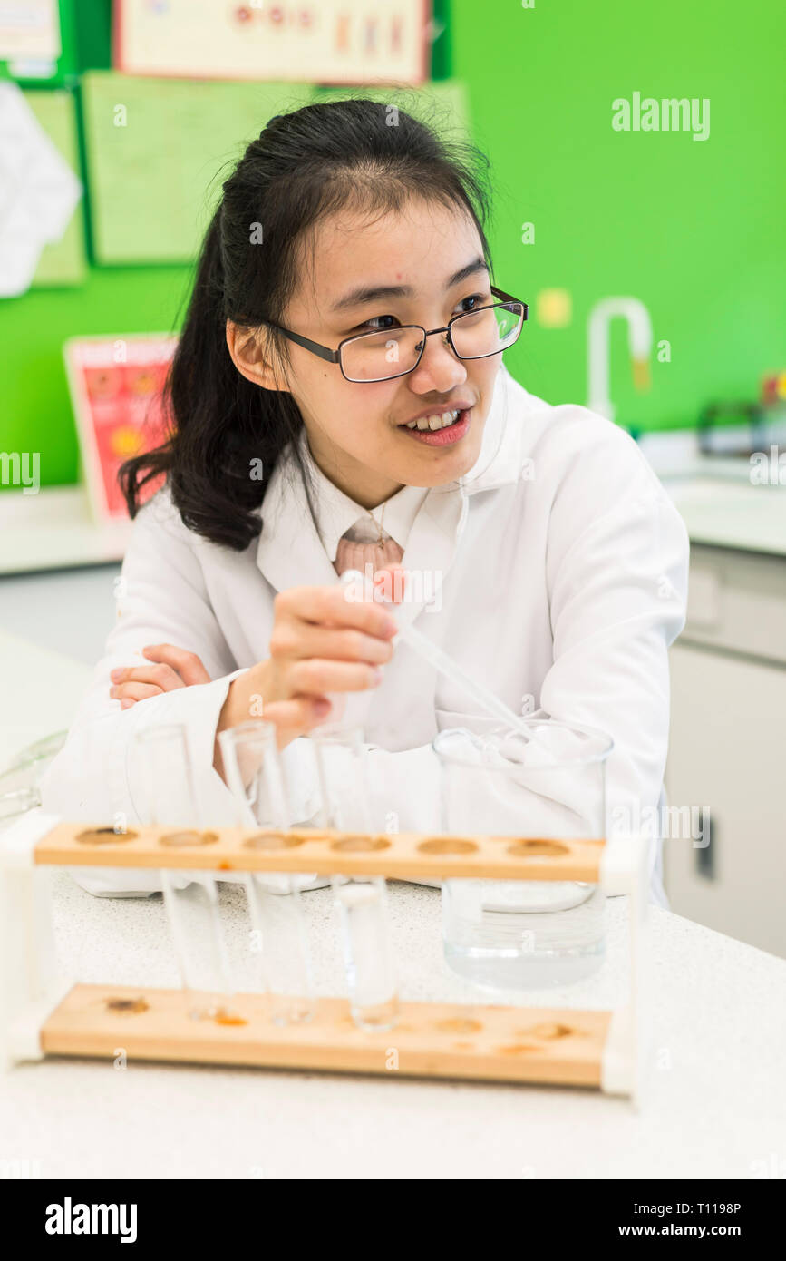 a female international asian student in the science lab of her college ...