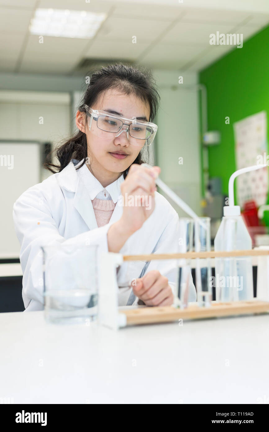 a female international asian student in the science lab of her college ...