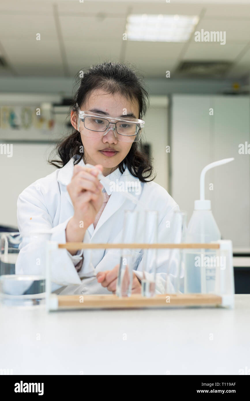 a female international asian student in the science lab of her college ...