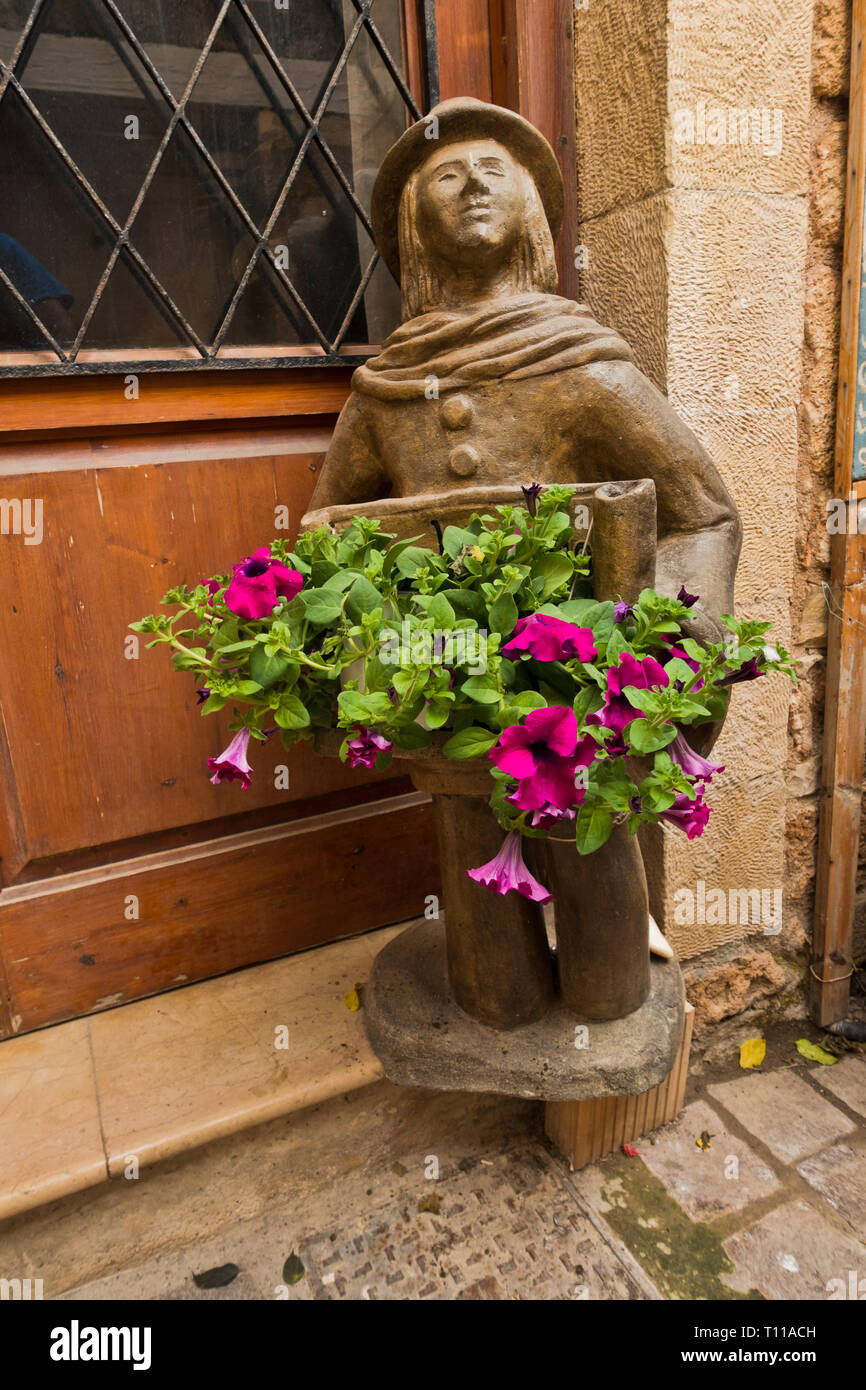 Interesting figurine and flower decoration at doorstep in a narrow ...