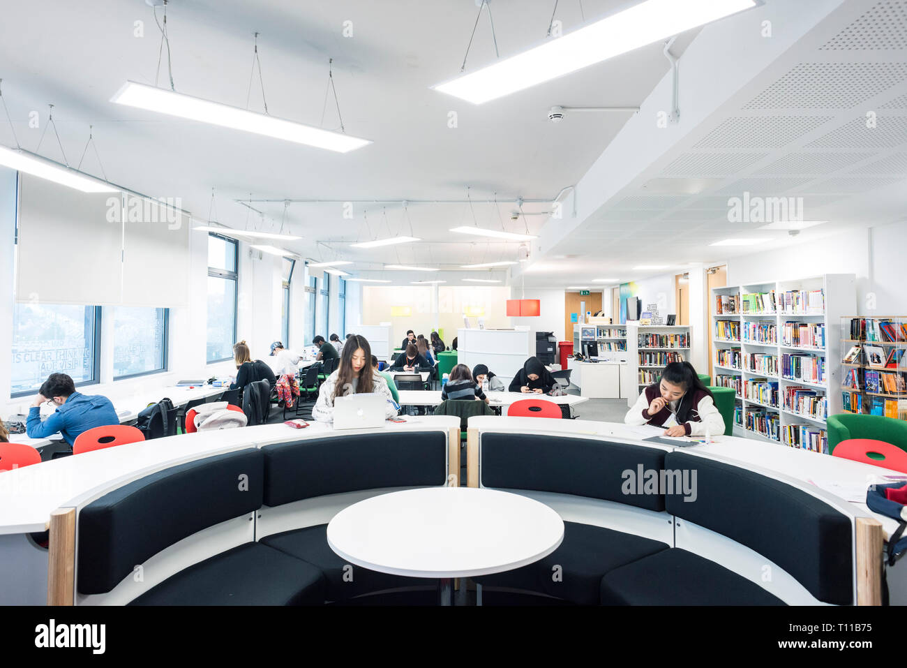 photos inside a college library with lots of students and books around ...