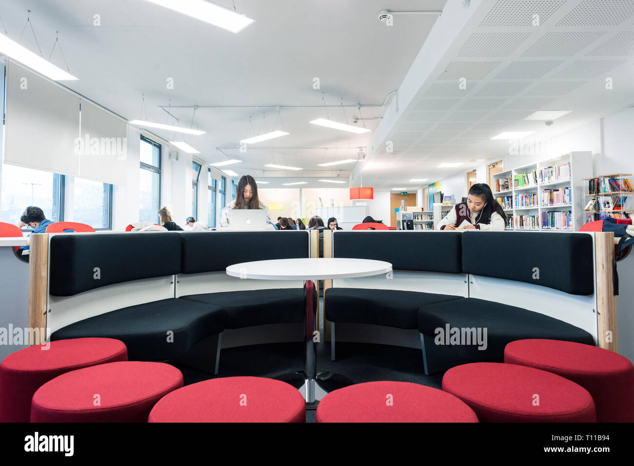 photos inside a college library with lots of students and books around ...