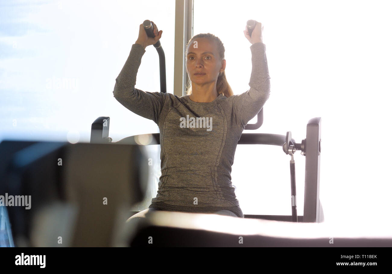 Woman of middle age working out in gym. Healthy lifestyle.Training on ...