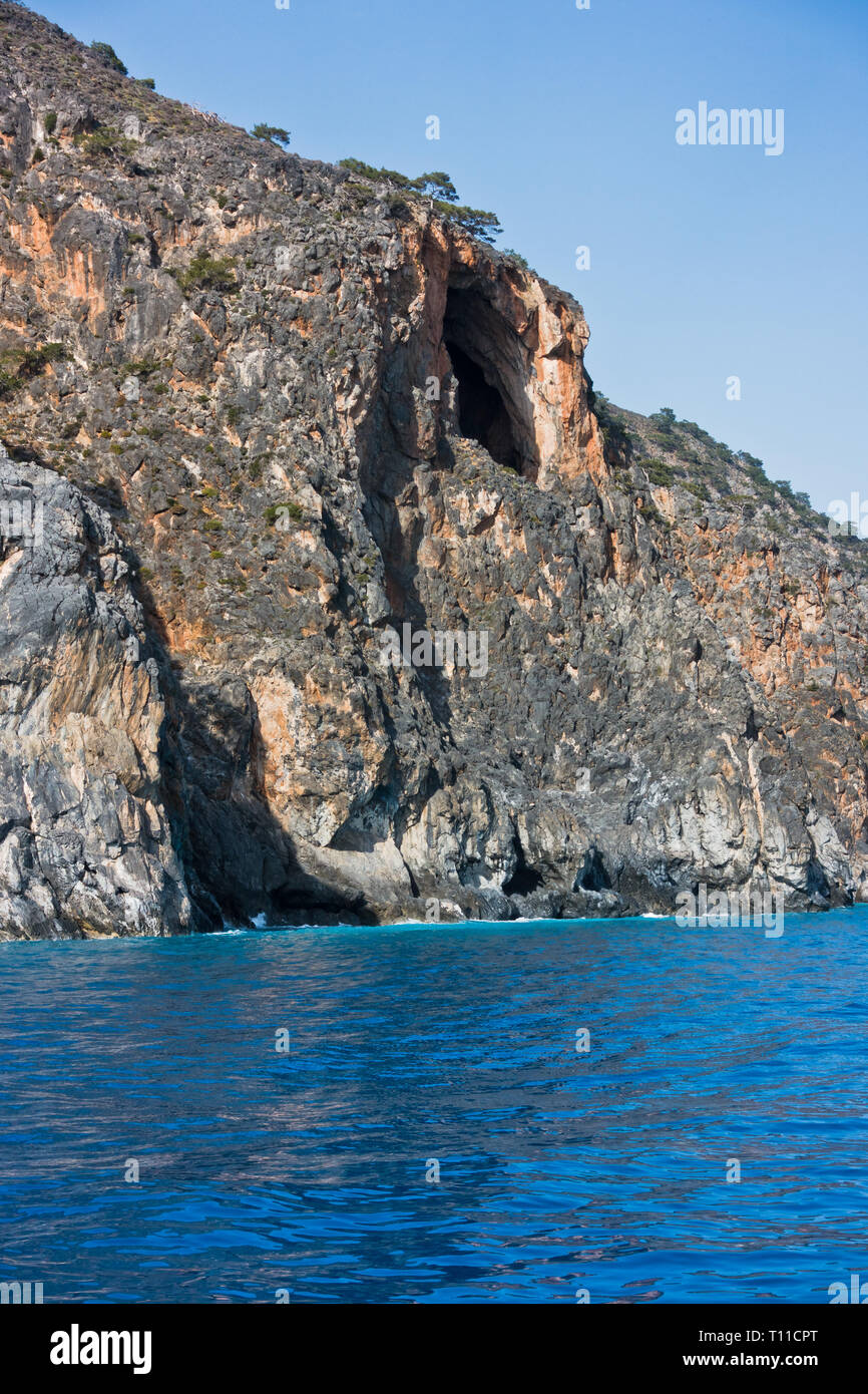 Cliffs with caves surrounding Domata beach, a view from ferry ona way ...