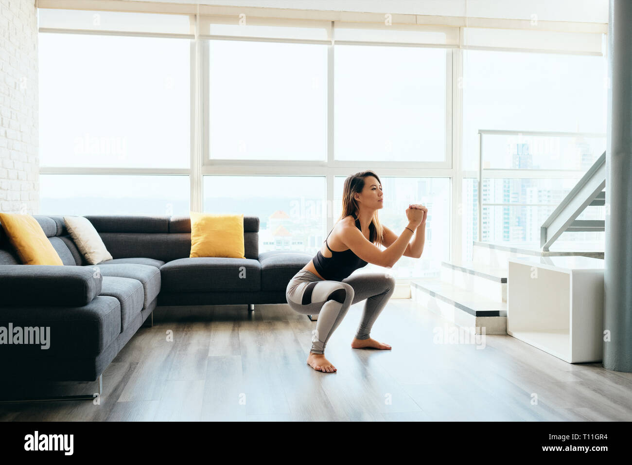 Fit young Pacific Islander woman training at home. Beautiful female ...