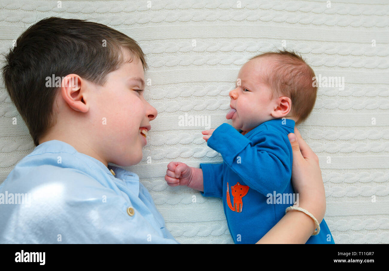 Big brother hugging his newborn baby. Toddler kid meeting new sibling ...