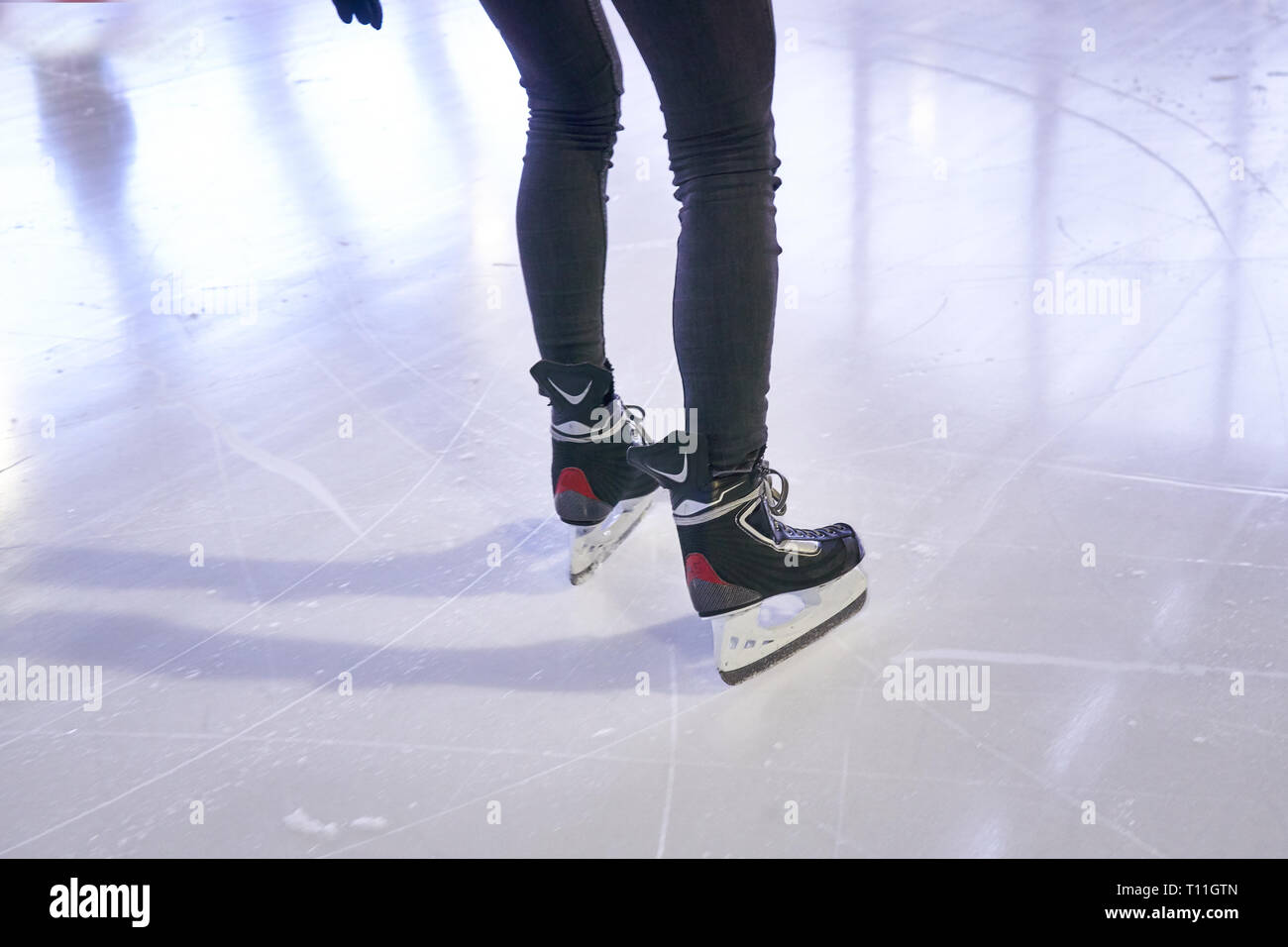 Legs of a woman skating on an ice rink Stock Photo - Alamy