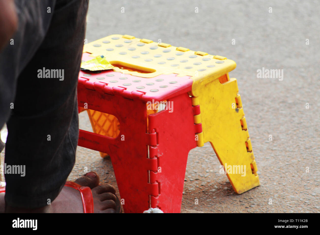 red and yellow color mini stool and a human leg Stock Photo - Alamy