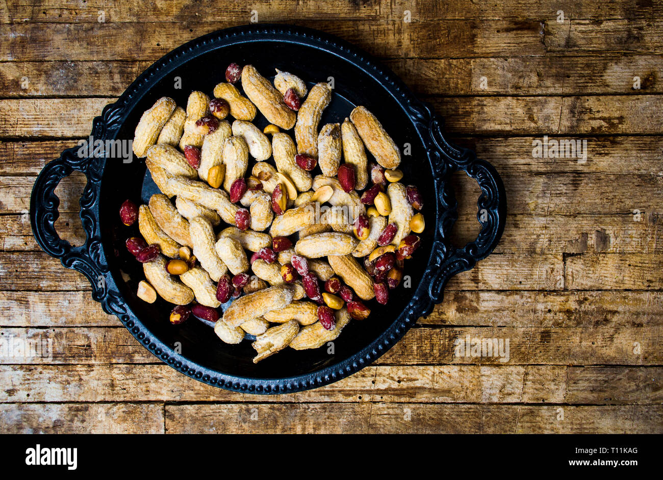 Roasted peanuts in a shell on a plate top view Stock Photo - Alamy