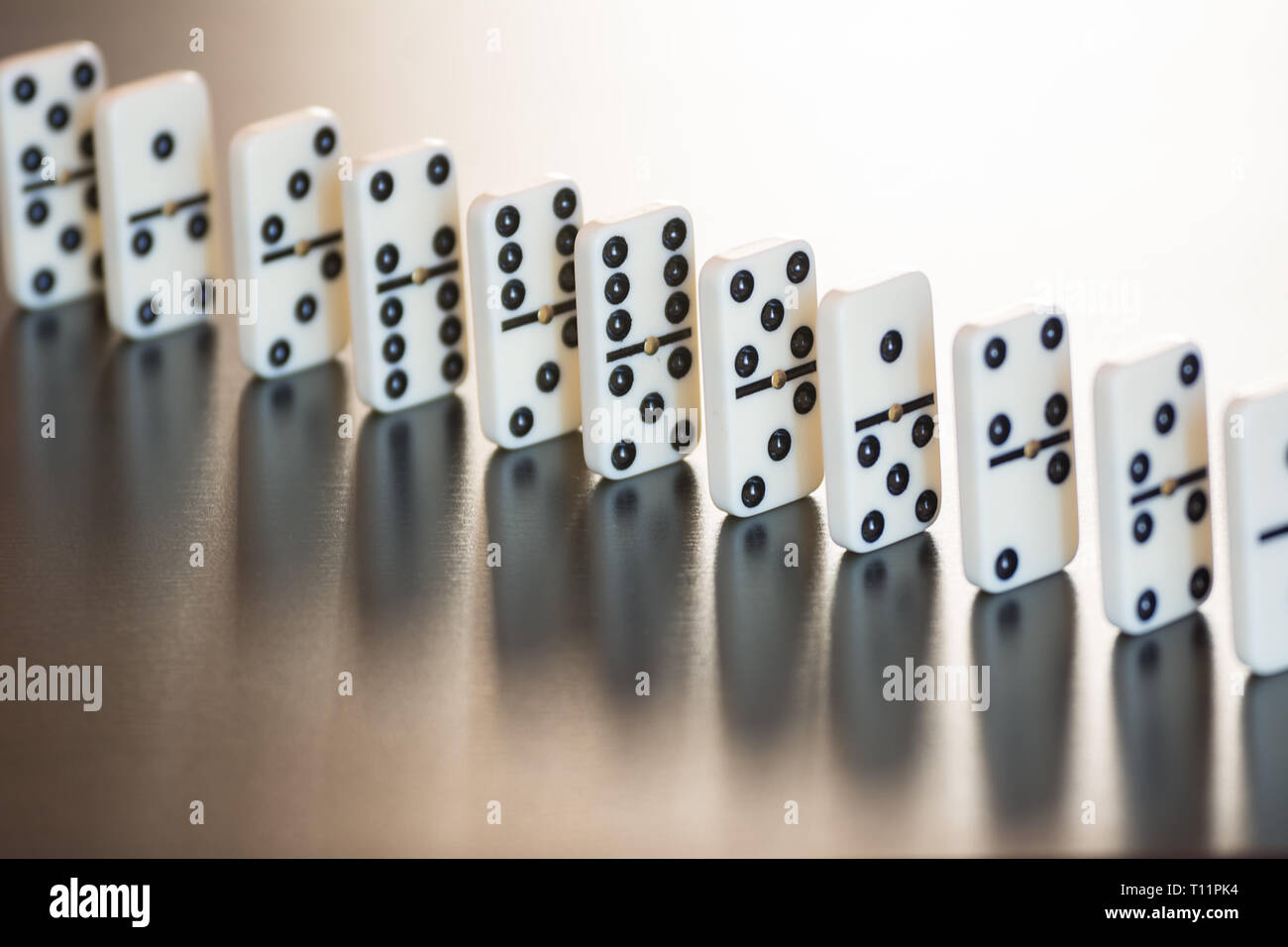 domino tiles in a row on a black background Stock Photo - Alamy